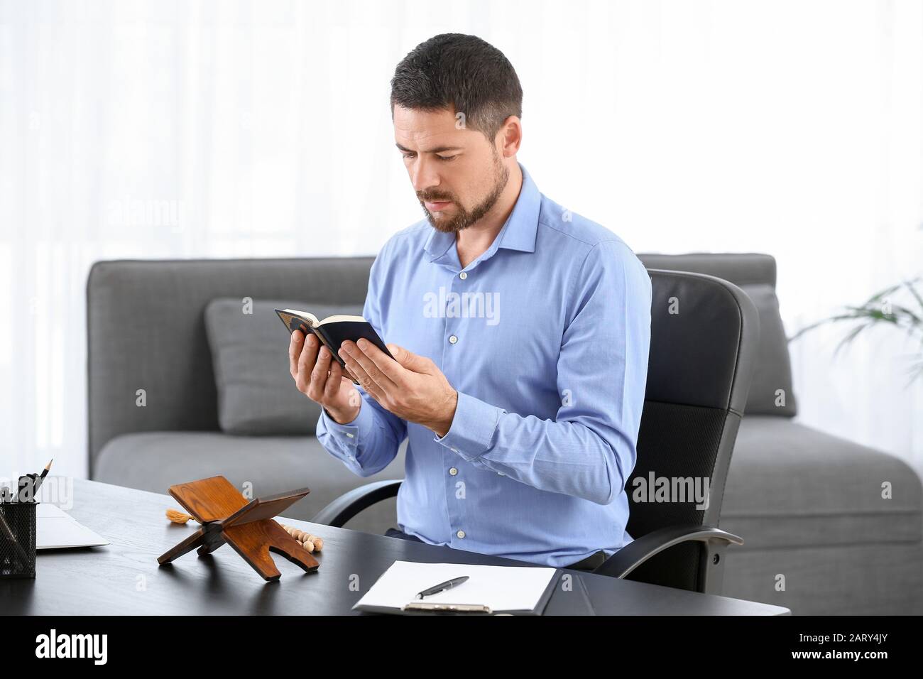 Muslim man praying in office Stock Photo - Alamy