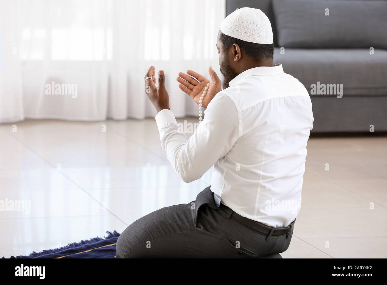 African-American Muslim man praying in office Stock Photo - Alamy