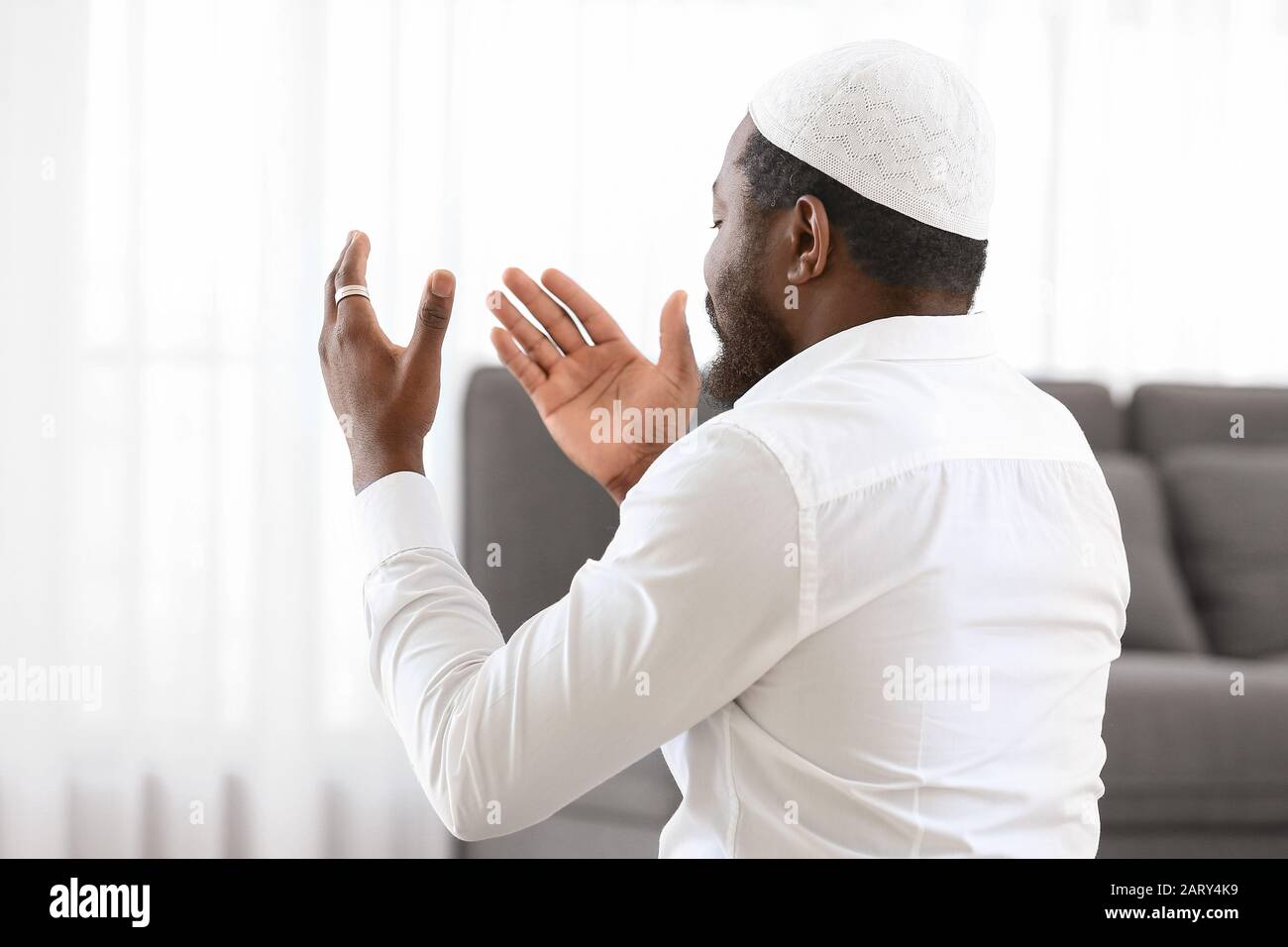 African-American Muslim man praying in office Stock Photo - Alamy