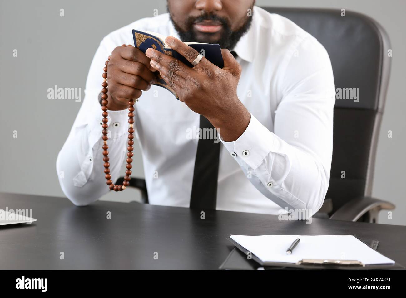 African-American Muslim man praying in office Stock Photo - Alamy