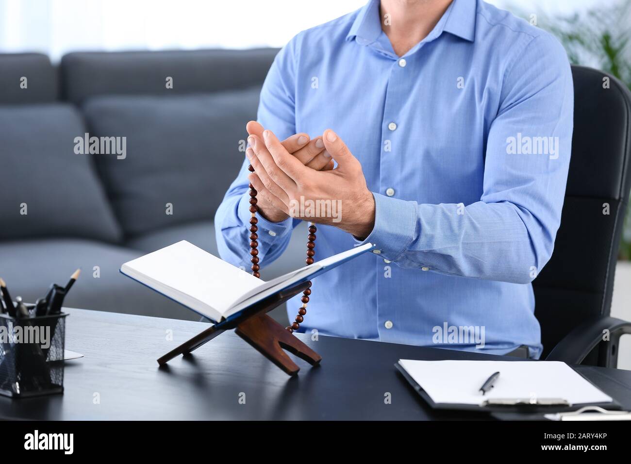 Muslim man praying in office Stock Photo - Alamy