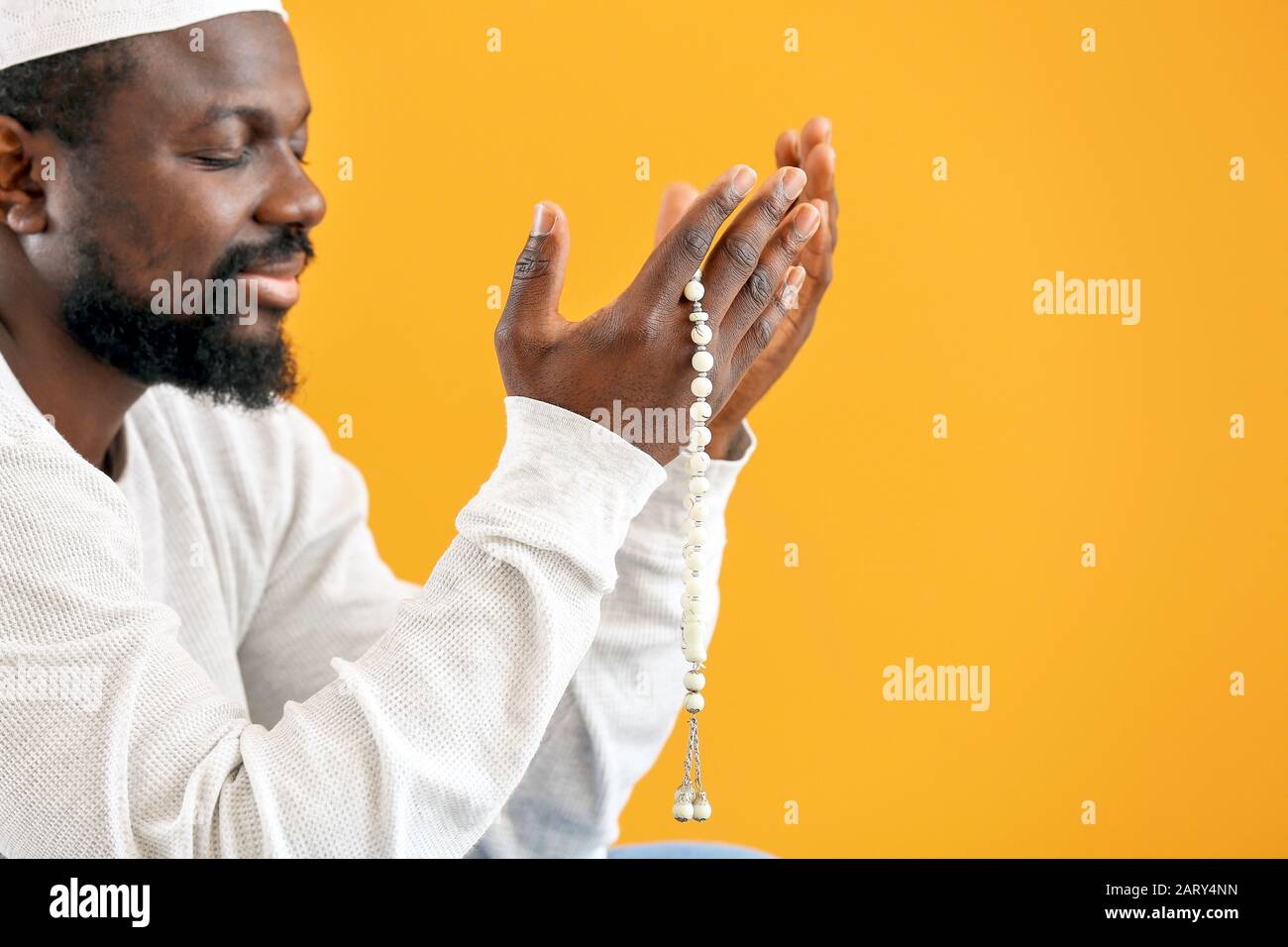 African-American Muslim man praying against color background Stock ...