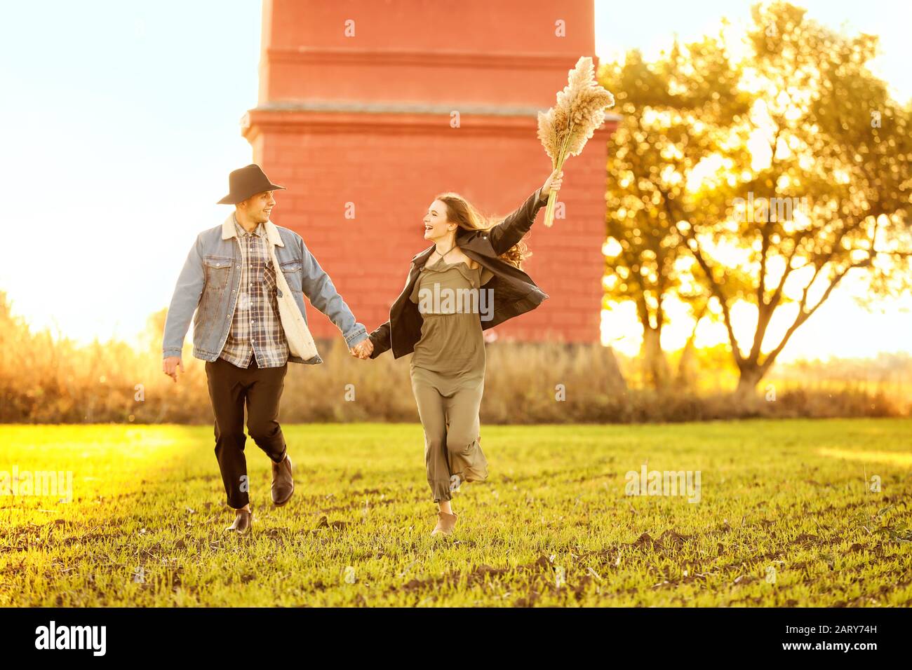 Romantic couple running in field hi-res stock photography and images ...