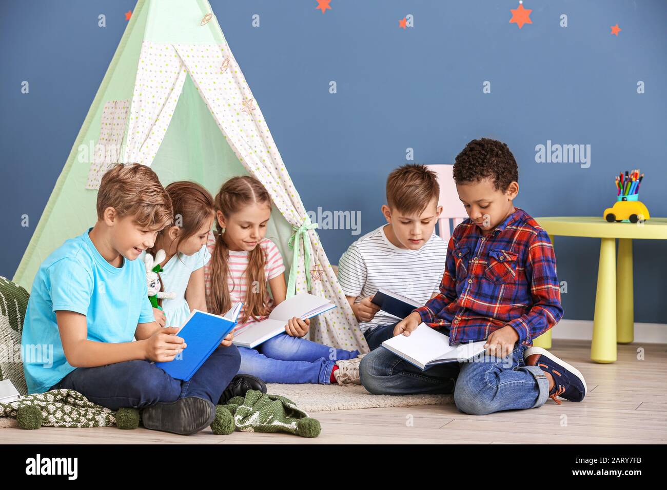 Cute little children reading books indoors Stock Photo - Alamy