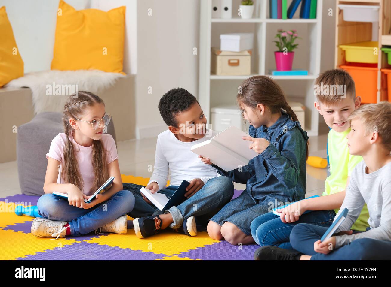 Cute little children reading books indoors Stock Photo - Alamy