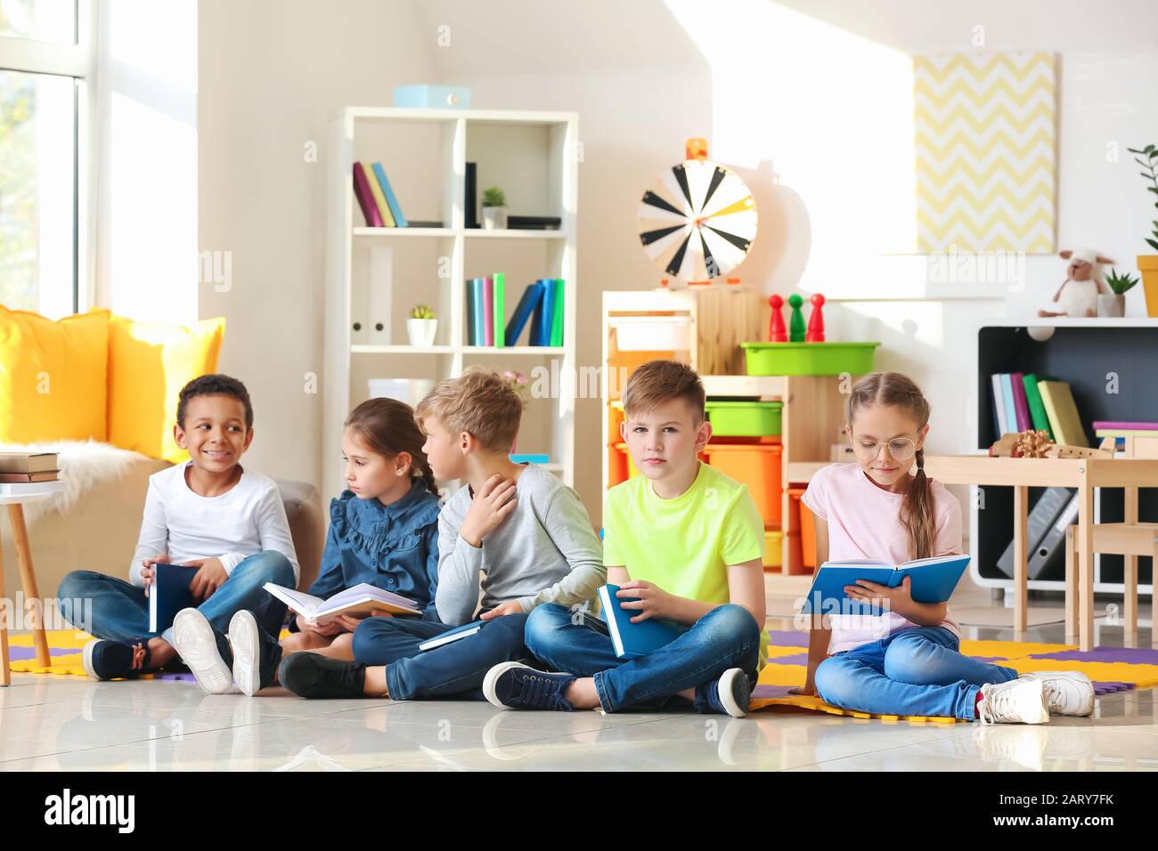 Cute little children reading books indoors Stock Photo - Alamy