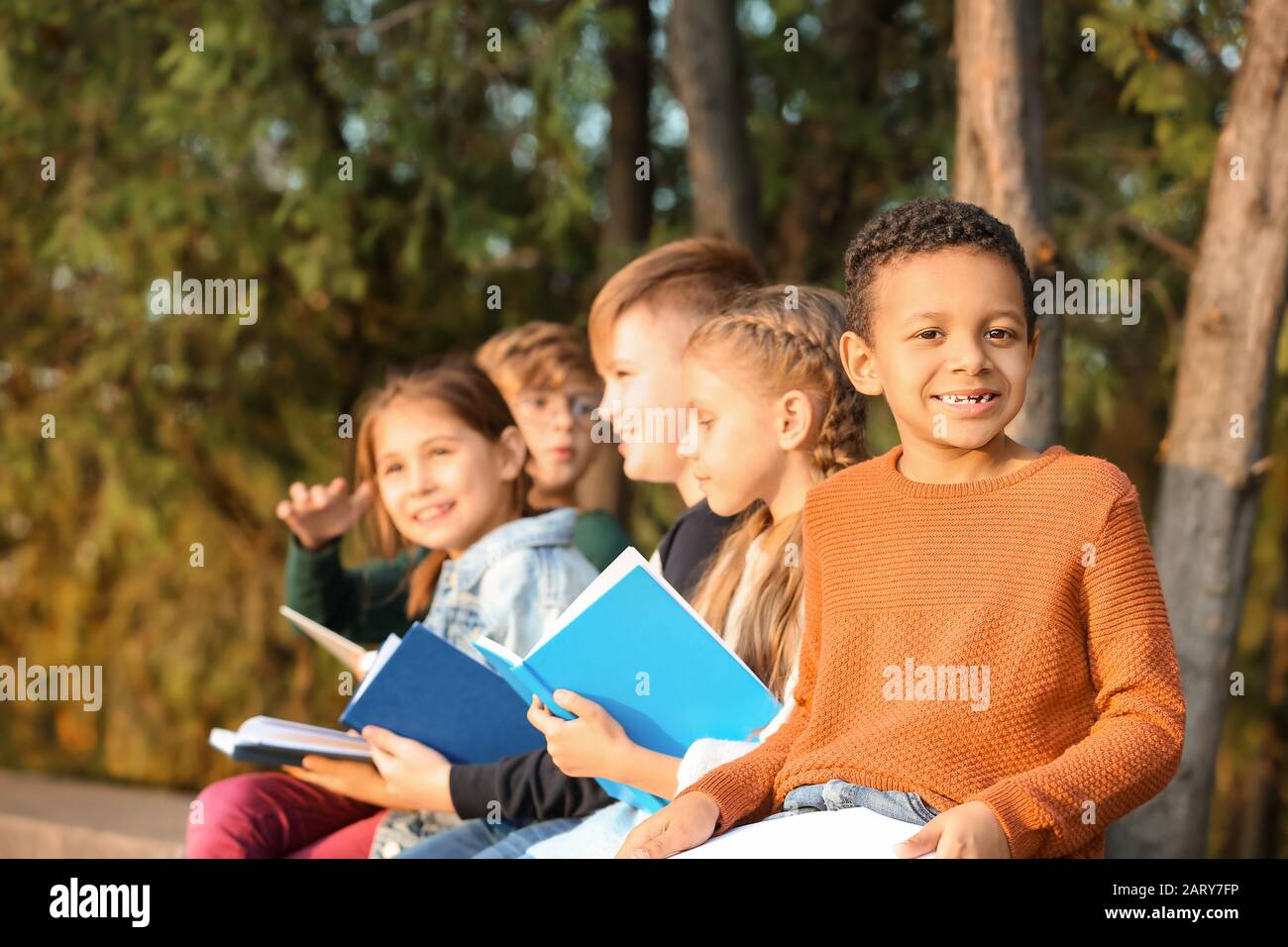 Cute little children reading books in park Stock Photo - Alamy
