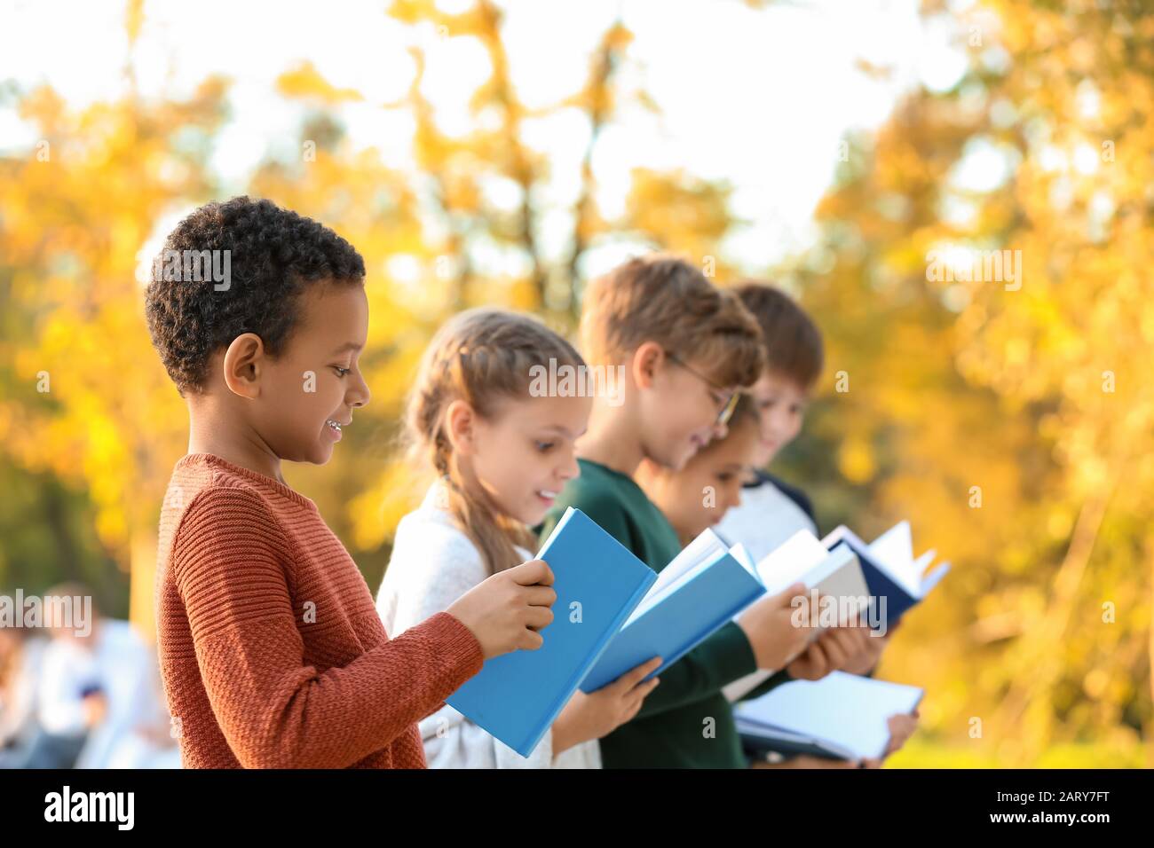 Cute little children reading books outdoors Stock Photo - Alamy