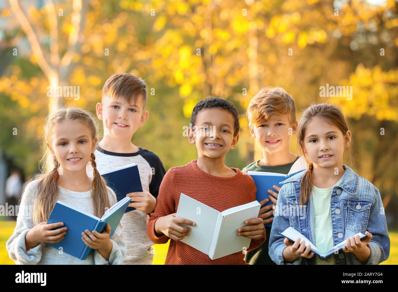 Cute little children reading books in park Stock Photo - Alamy