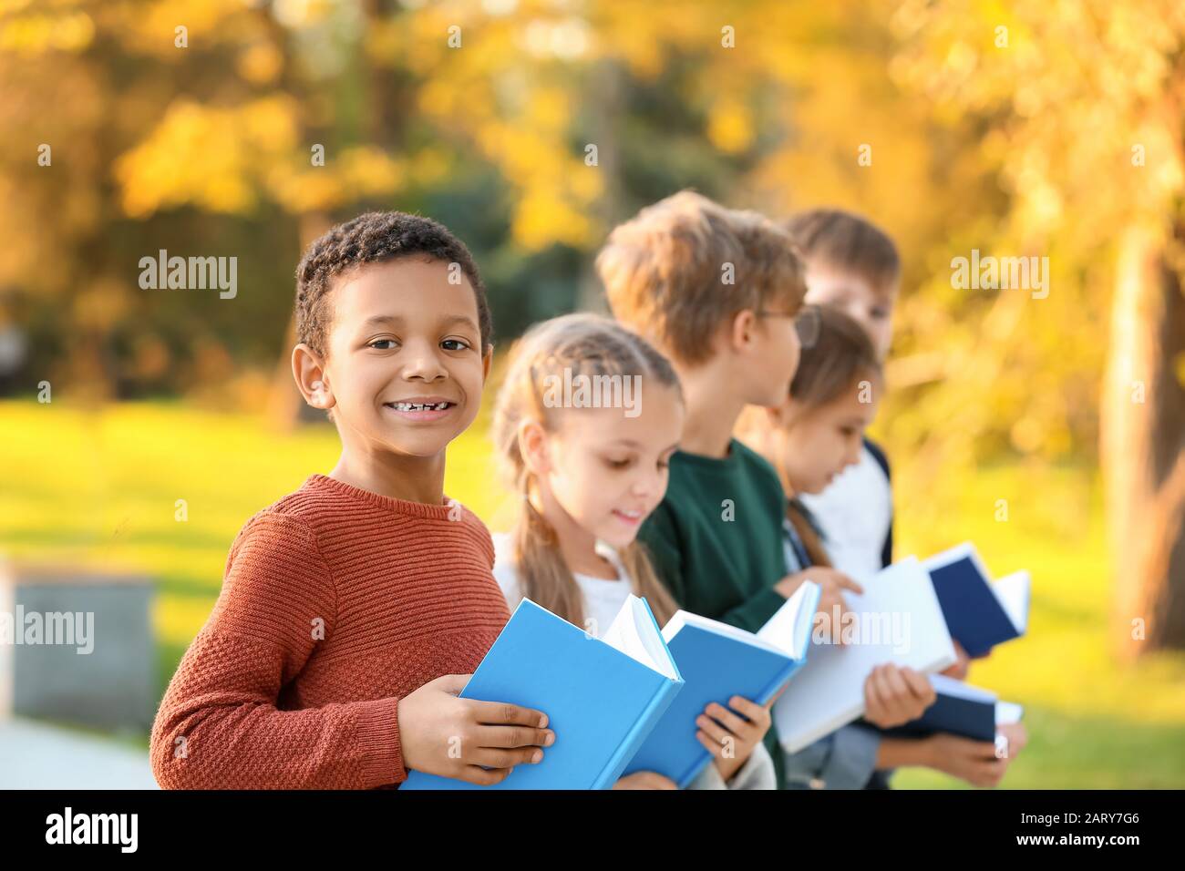 Cute little children reading books outdoors Stock Photo - Alamy
