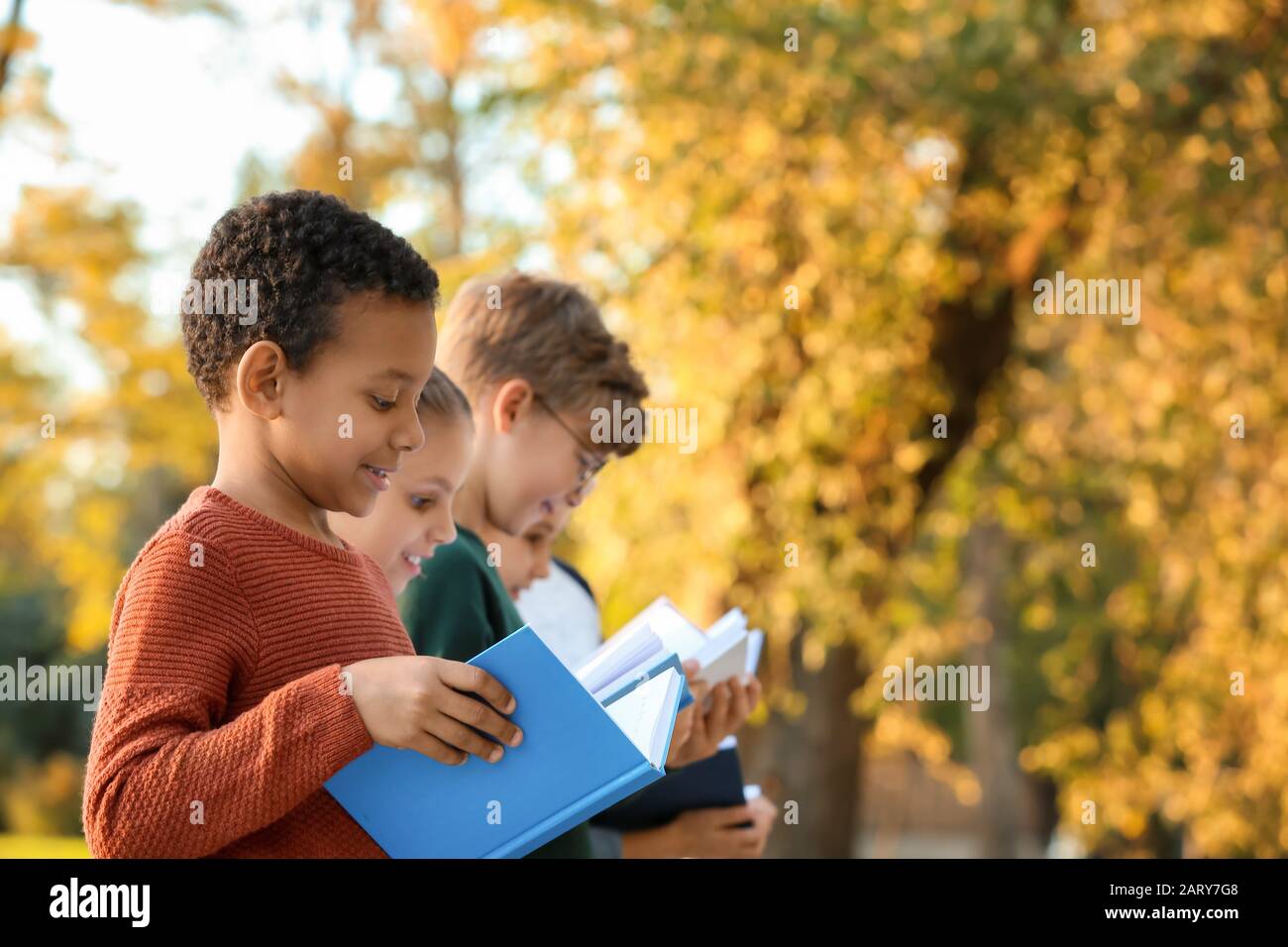 Cute little children reading books in park Stock Photo - Alamy