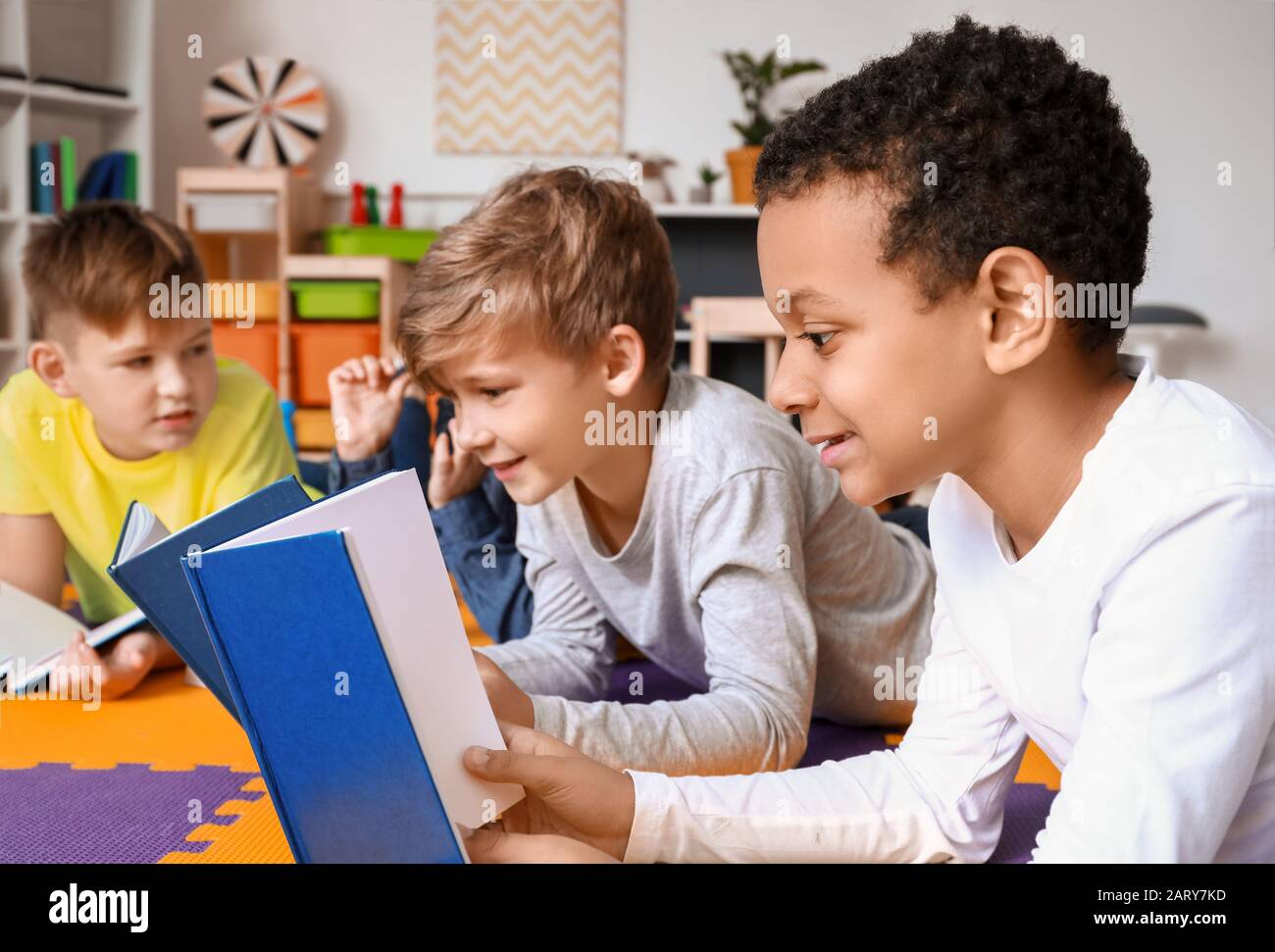 Cute little children reading books indoors Stock Photo - Alamy