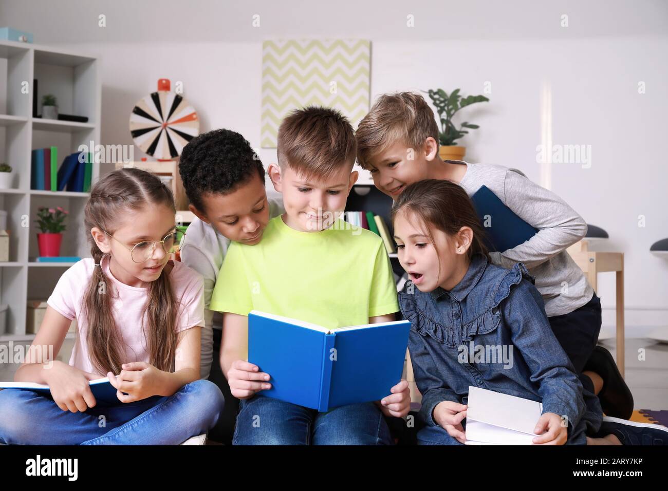 Cute little children reading book indoors Stock Photo - Alamy
