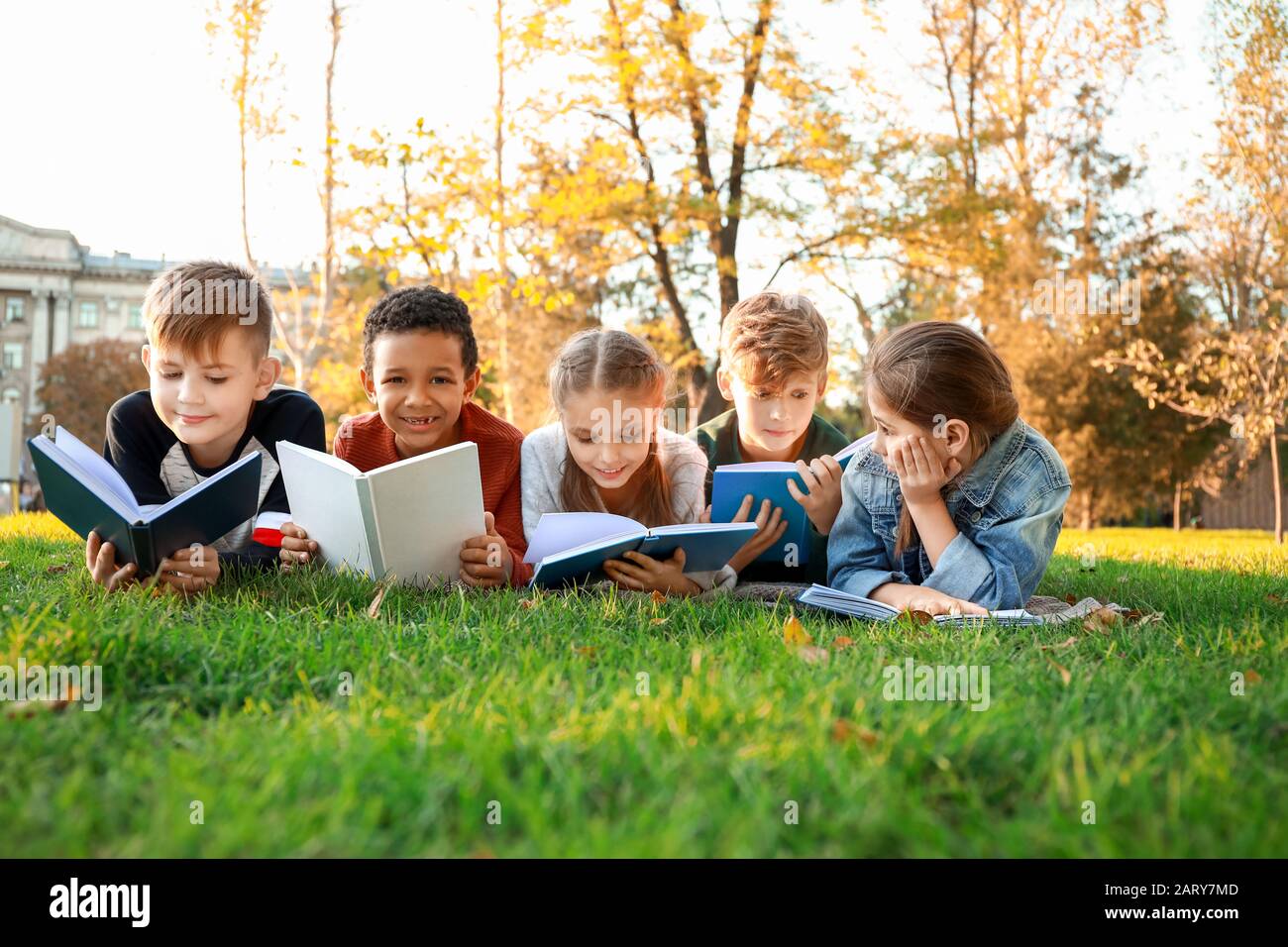 Cute little children reading books in park Stock Photo - Alamy