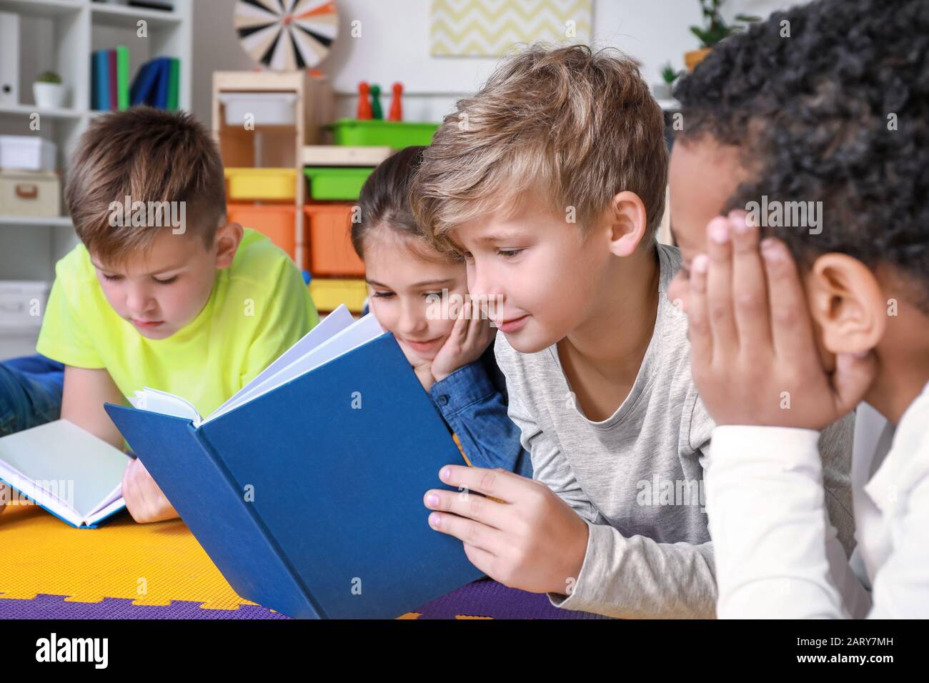 Cute little children reading books indoors Stock Photo - Alamy