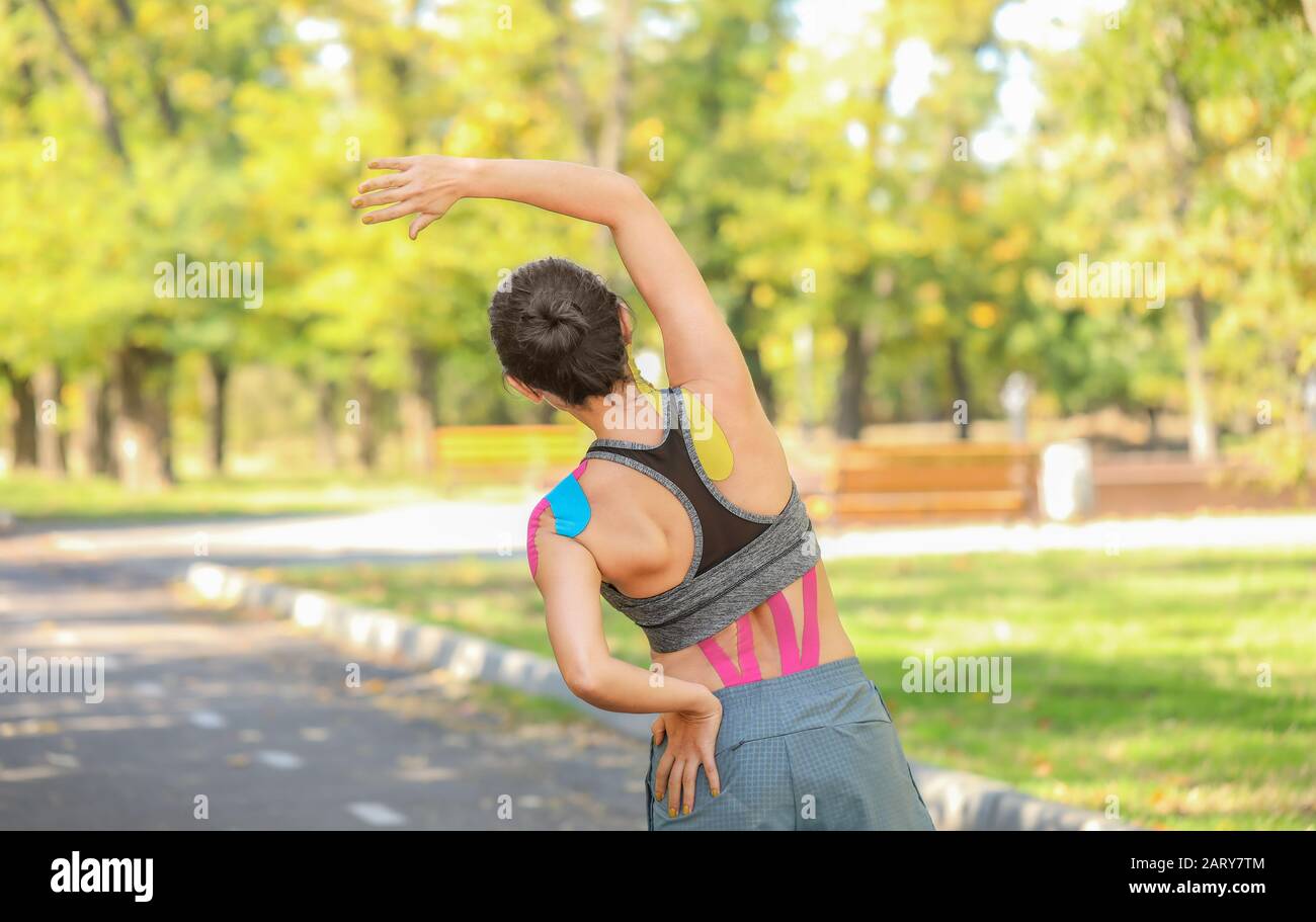 Sporty woman with physio tape applied on back outdoors Stock Photo - Alamy