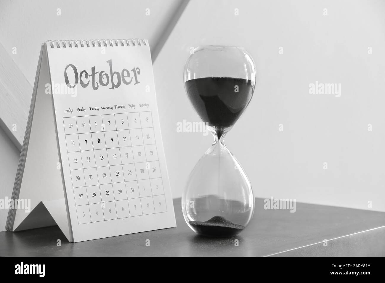Calendar with hourglass on table Stock Photo - Alamy