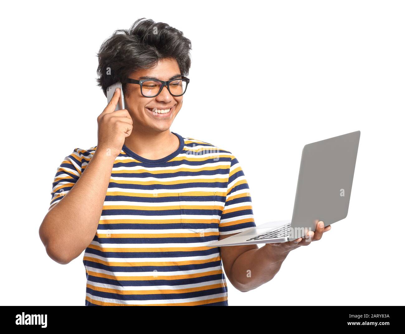 Male Asian programmer with laptop talking by mobile phone on white ...
