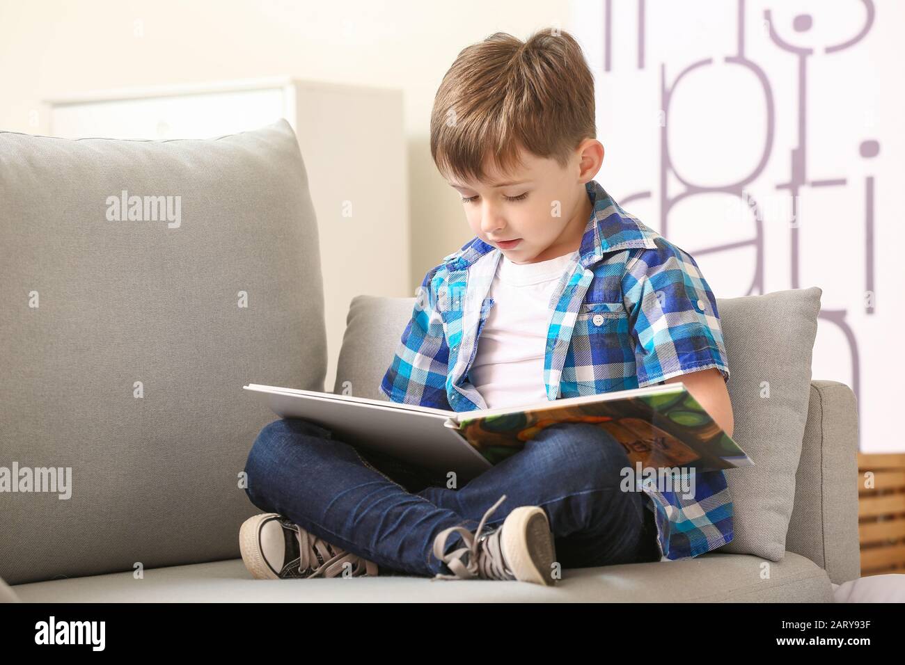 Cute little boy reading book at home Stock Photo - Alamy