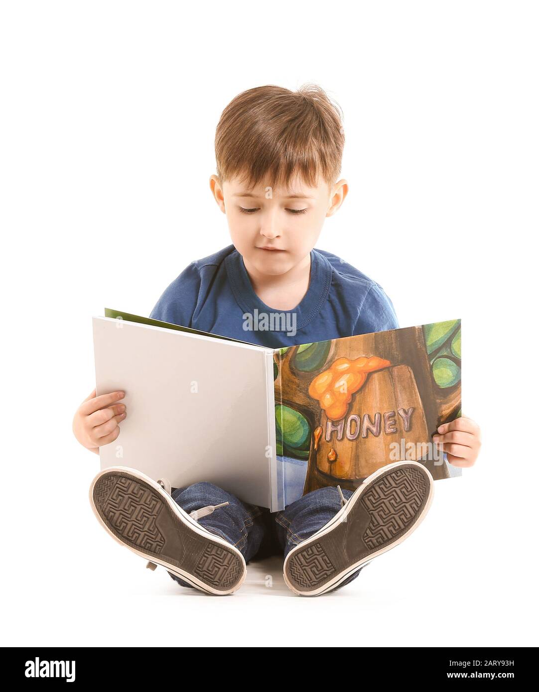 Cute little boy reading book on white background Stock Photo - Alamy