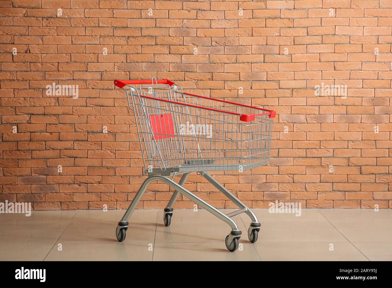 Empty shopping cart near brick wall Stock Photo - Alamy