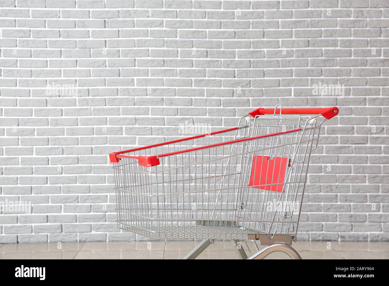 Empty shopping cart near brick wall Stock Photo - Alamy