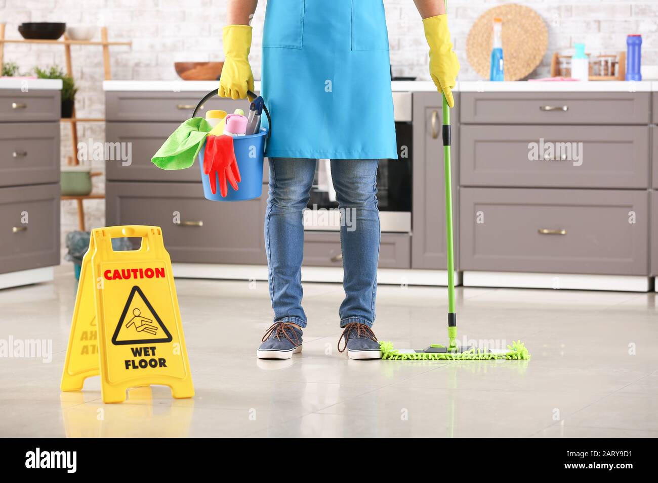 Male janitor with cleaning supplies in kitchen Stock Photo - Alamy