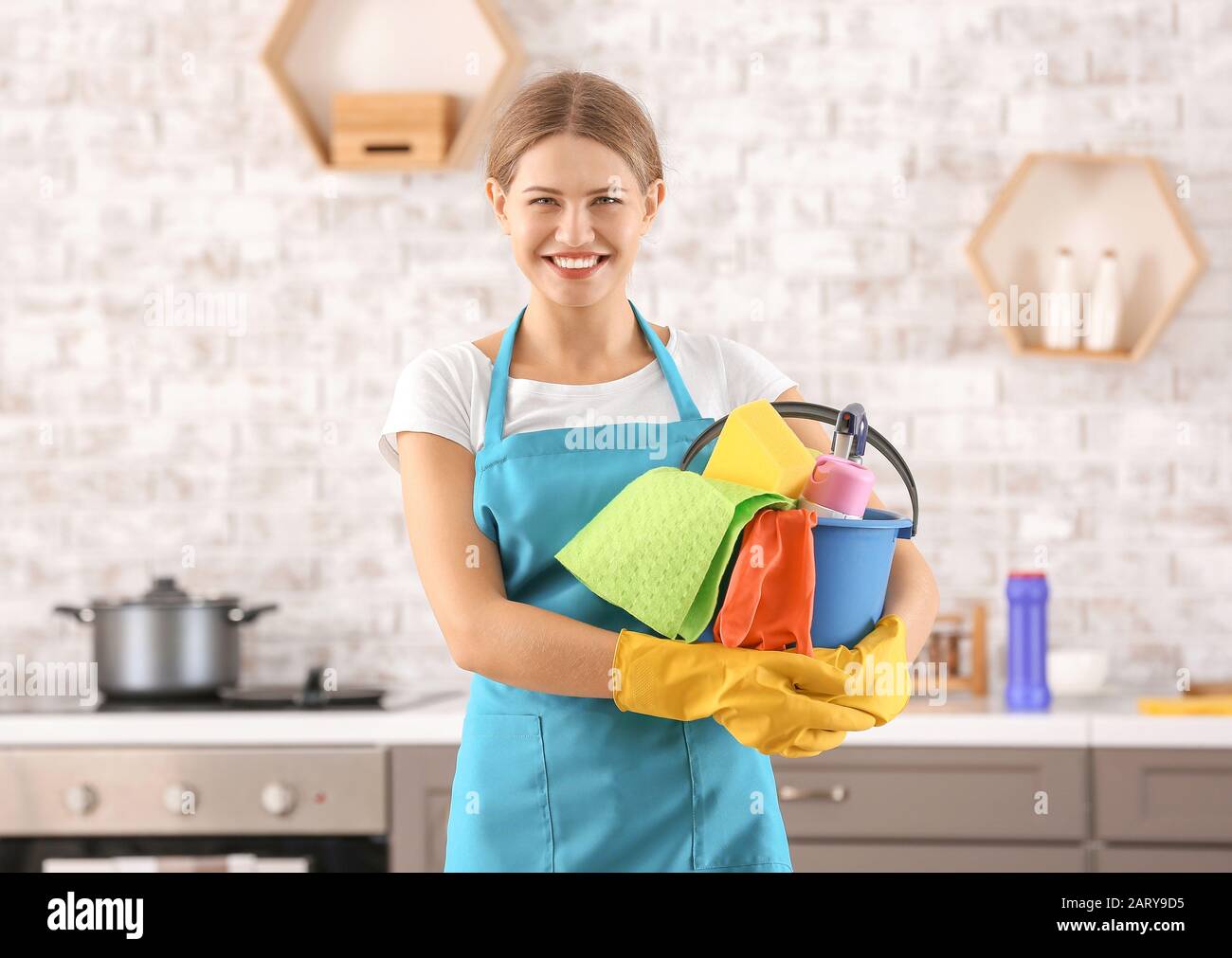 Female janitor with cleaning supplies in kitchen Stock Photo - Alamy