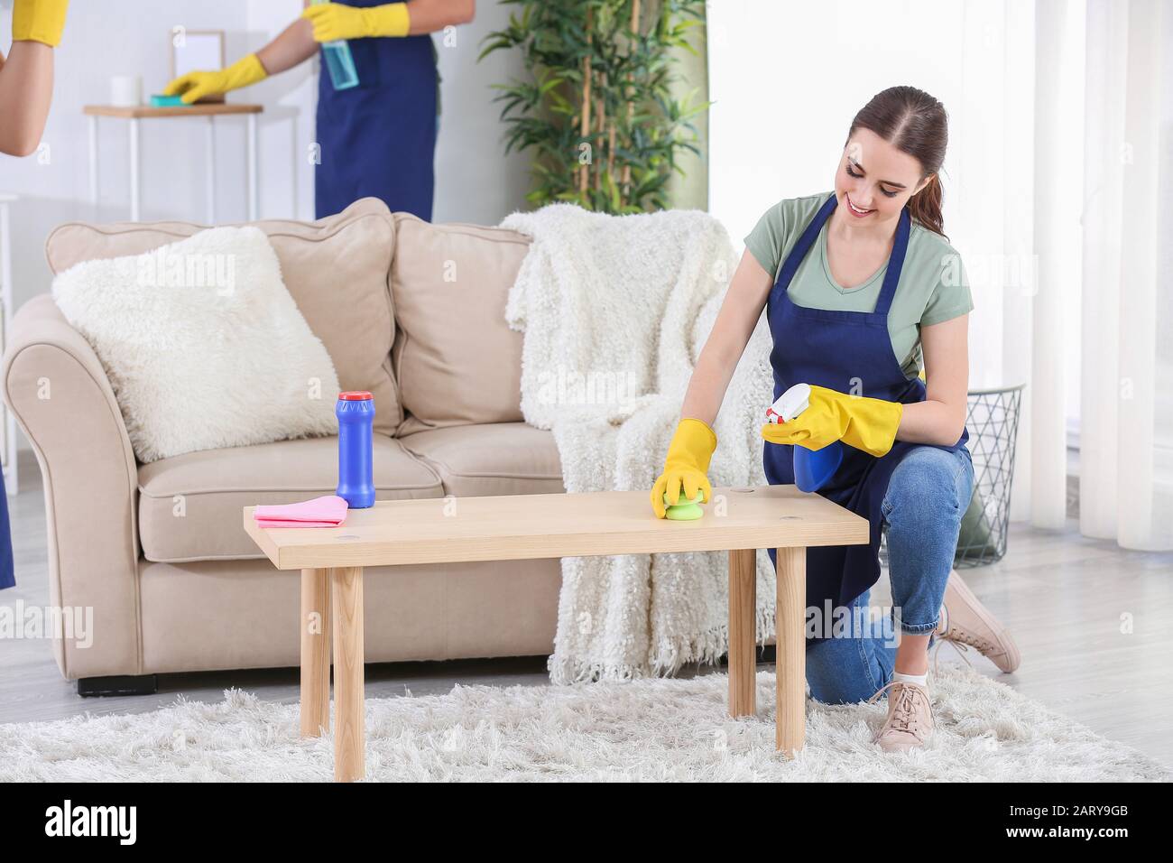 Female janitor cleaning table in room Stock Photo - Alamy