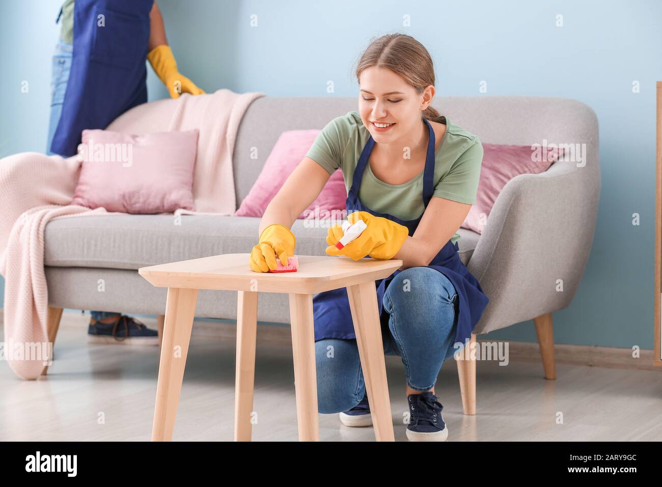 Female janitor cleaning table in room Stock Photo - Alamy