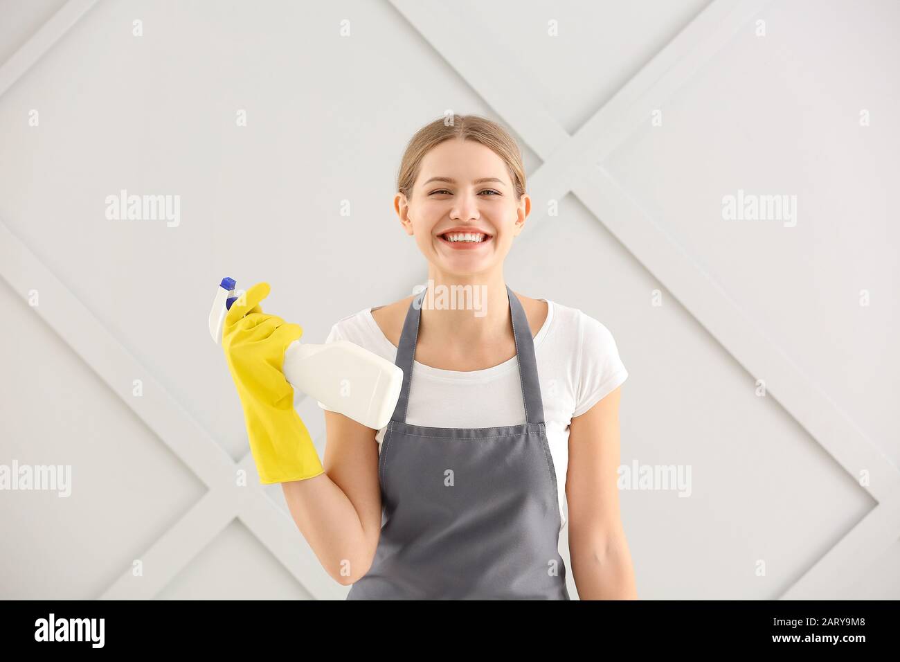 Female janitor on grey background Stock Photo - Alamy