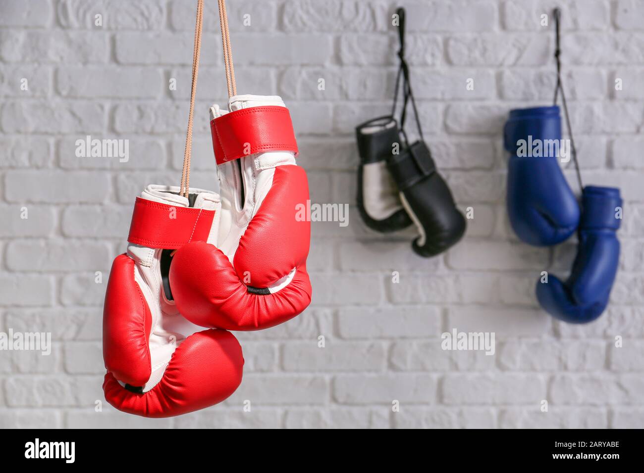 Boxing gloves hanging against brick wall Stock Photo - Alamy