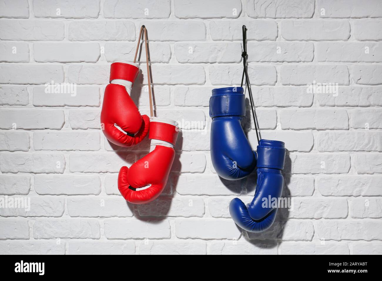 Boxing gloves hanging on brick wall Stock Photo - Alamy