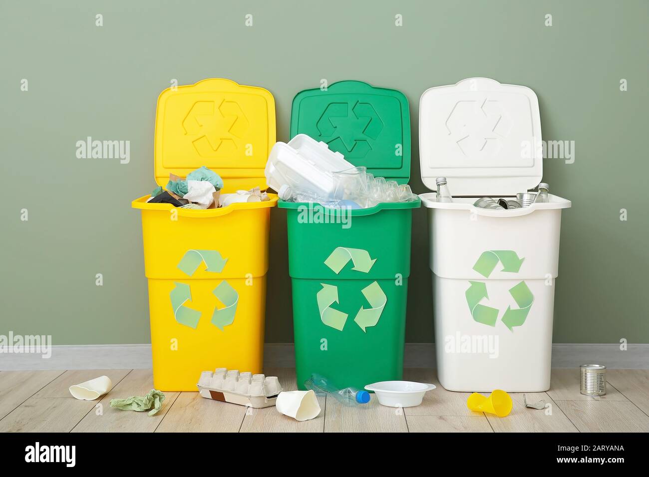 Containers with different types of garbage near color wall. Recycling ...