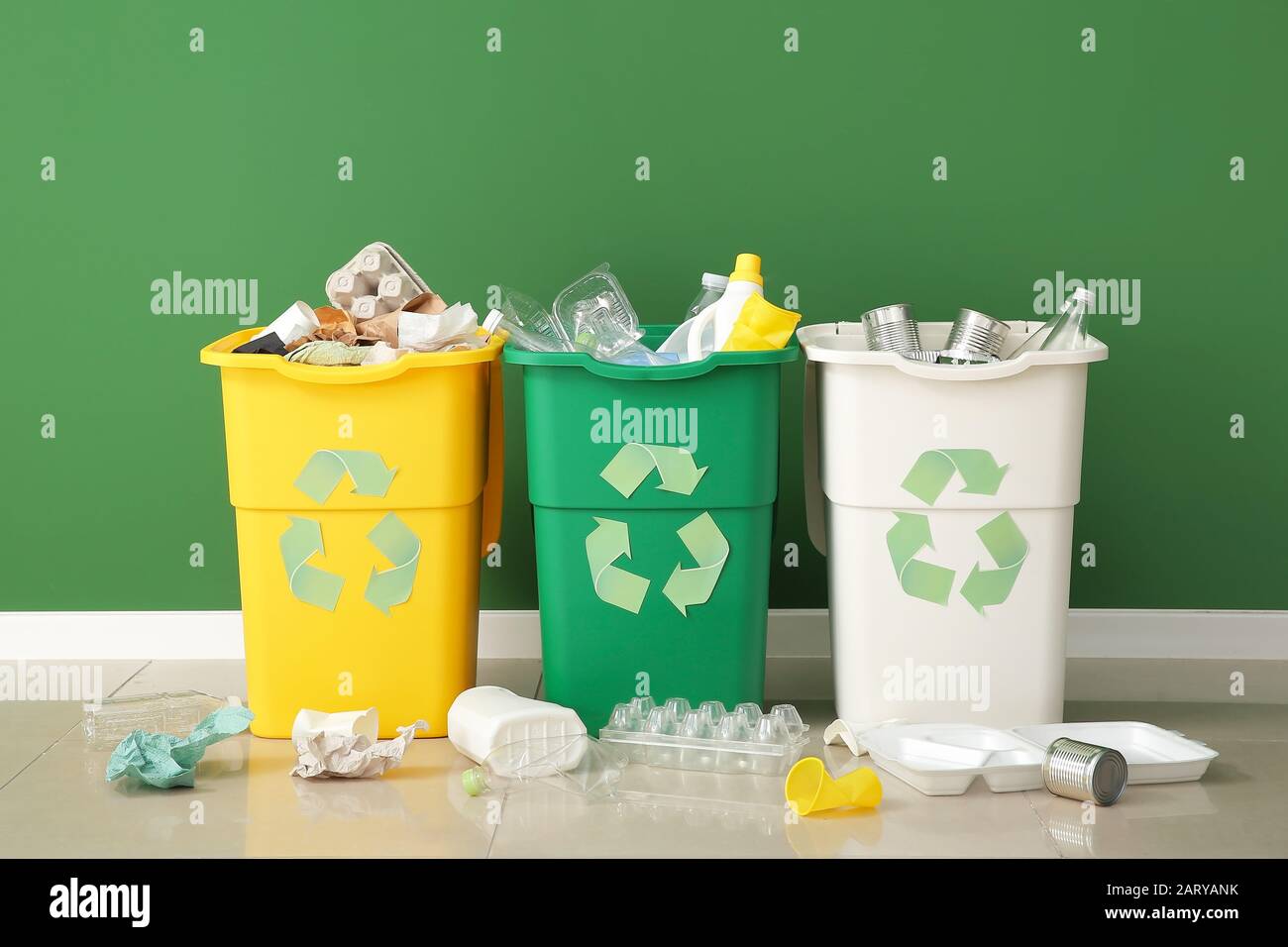 Containers with different types of garbage near color wall. Recycling ...