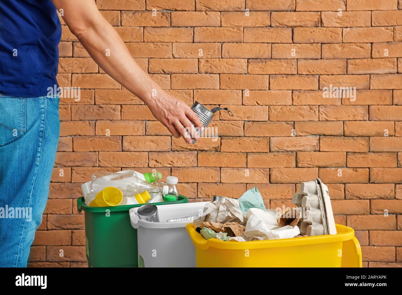 Man throwing garbage into container. Recycling concept Stock Photo - Alamy