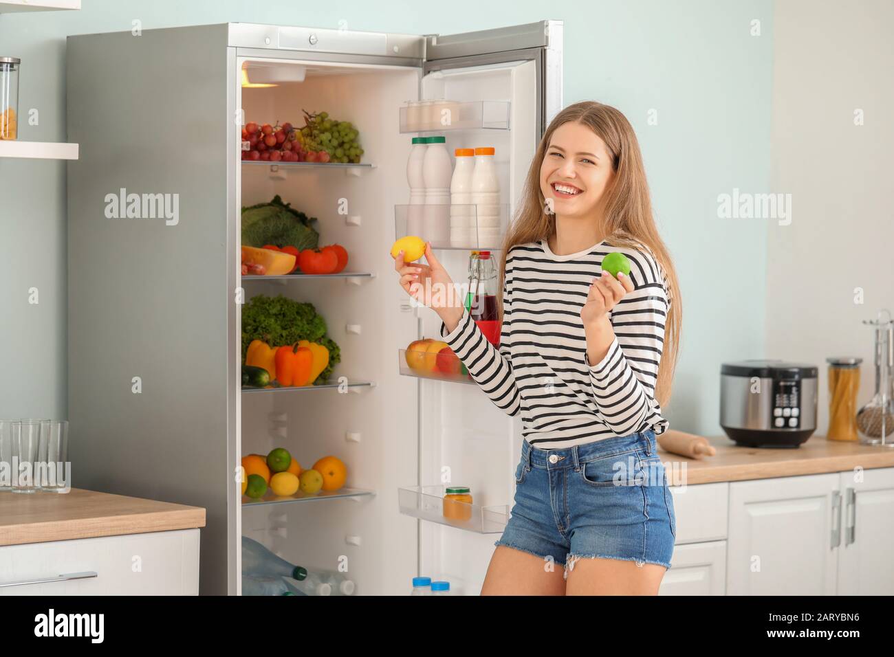 Woman taking food out of fridge at home Stock Photo - Alamy