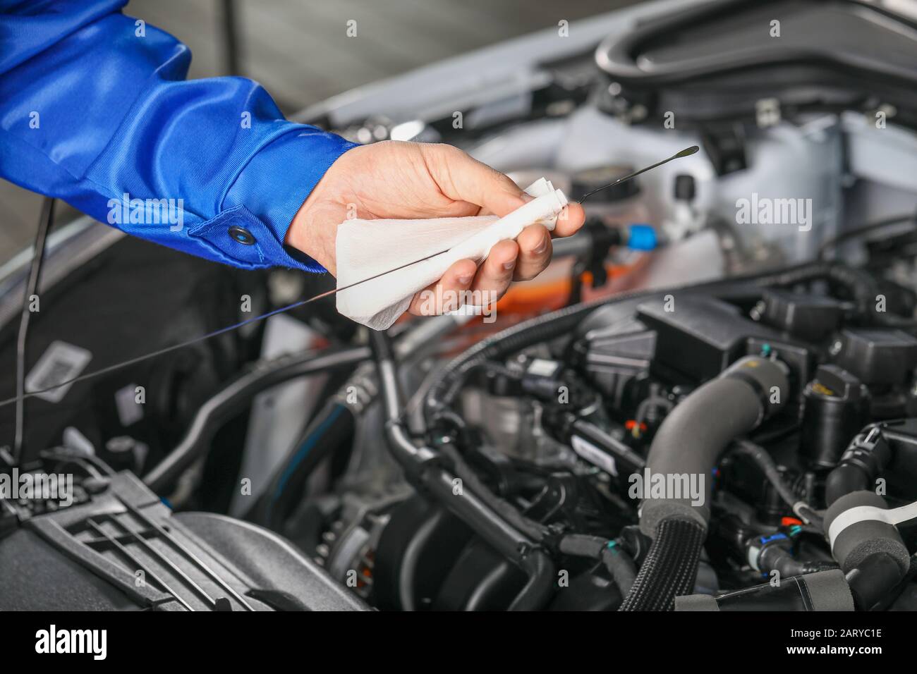 Male mechanic checking level of oil in car engine Stock Photo - Alamy