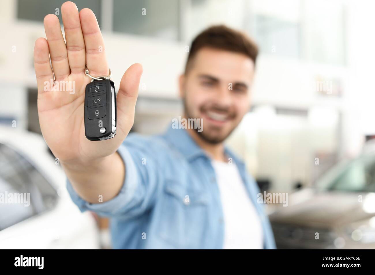 Happy man with key from new car in salon, closeup Stock Photo - Alamy
