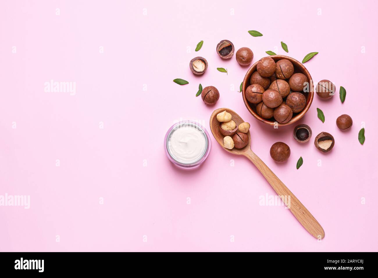 Macadamia nuts with cream on color background Stock Photo - Alamy