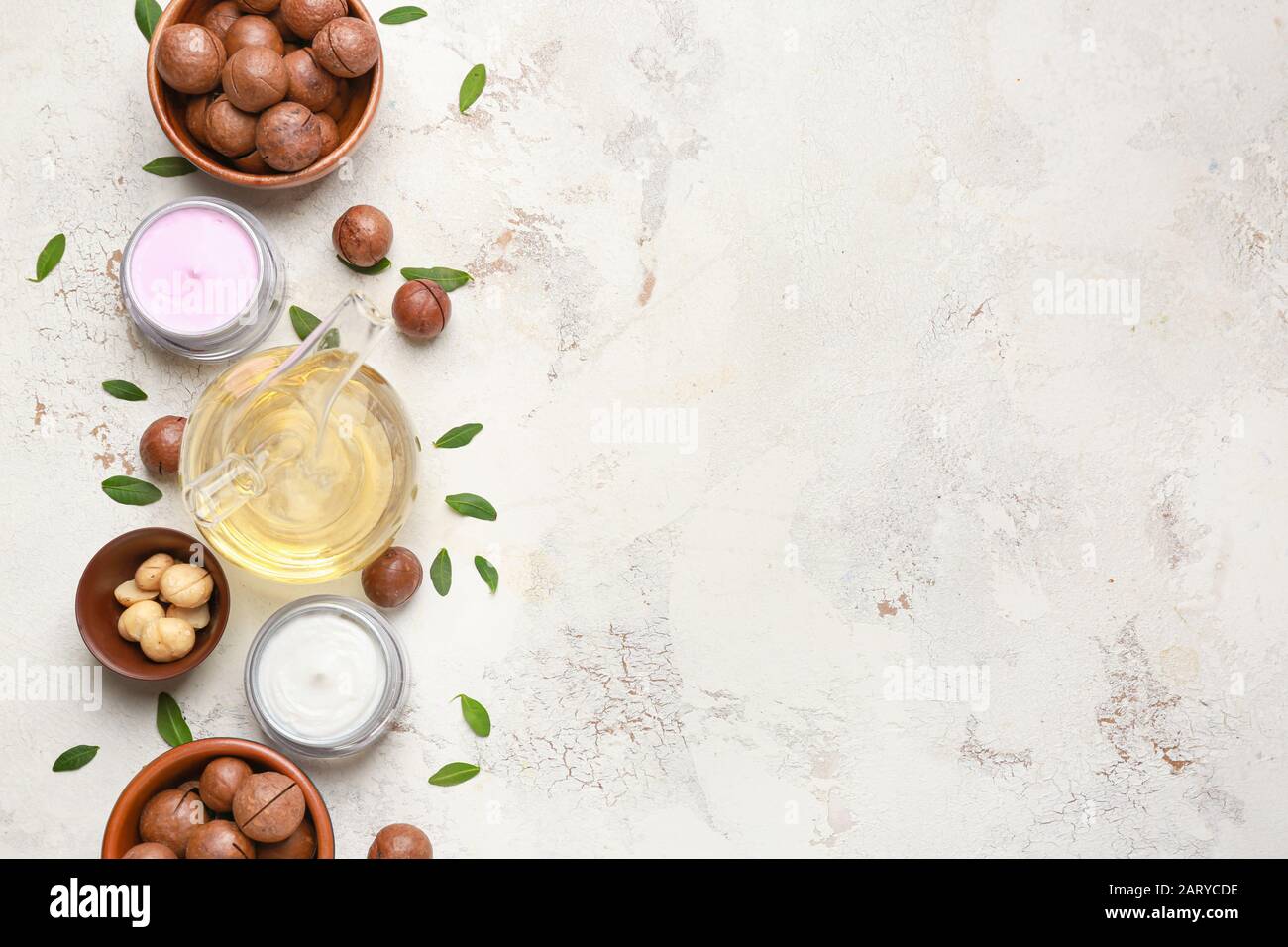 Macadamia nuts with oil and cosmetic cream on white background Stock ...