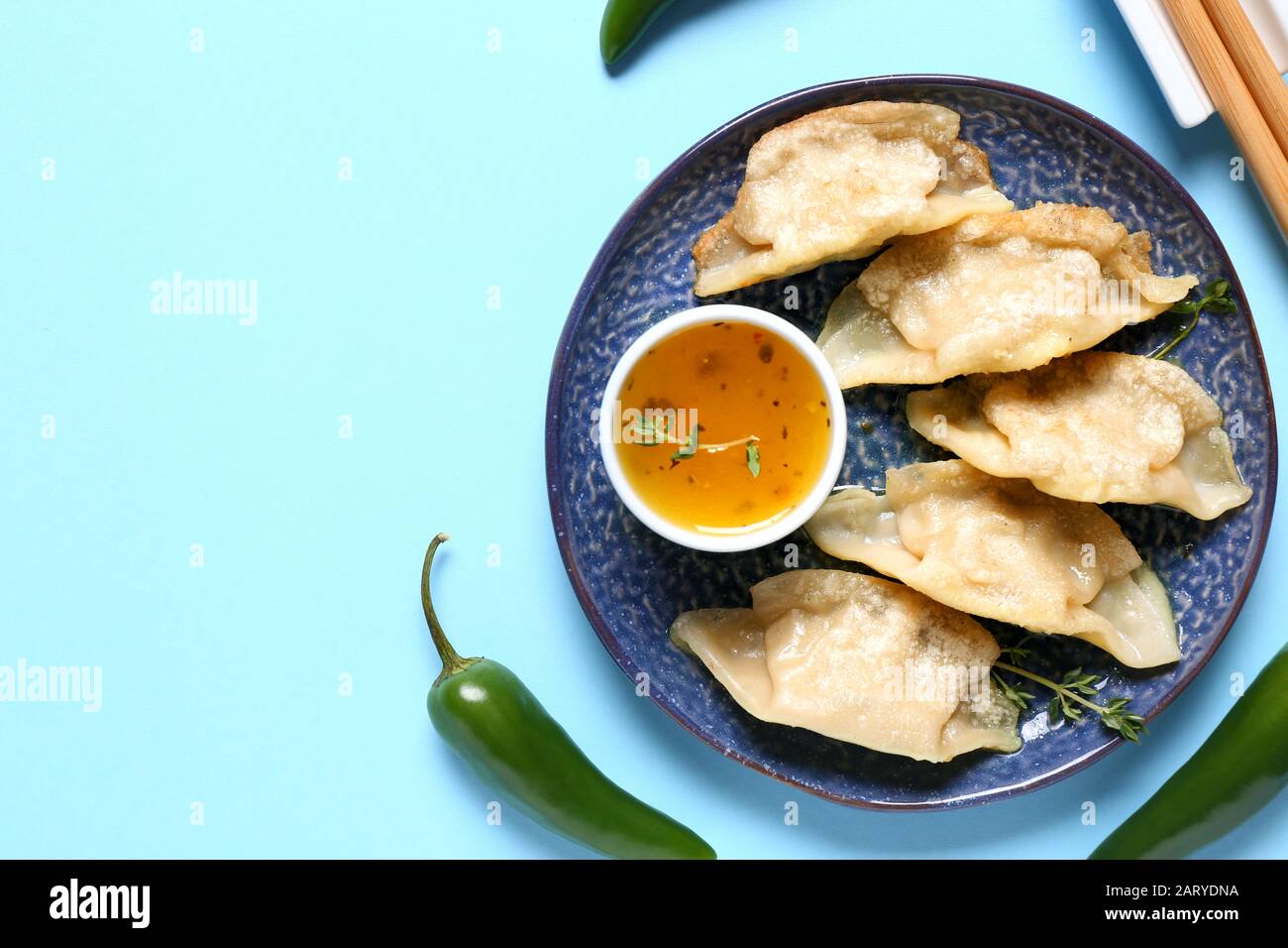 Plate with tasty Japanese gyoza and sauce on color background Stock ...