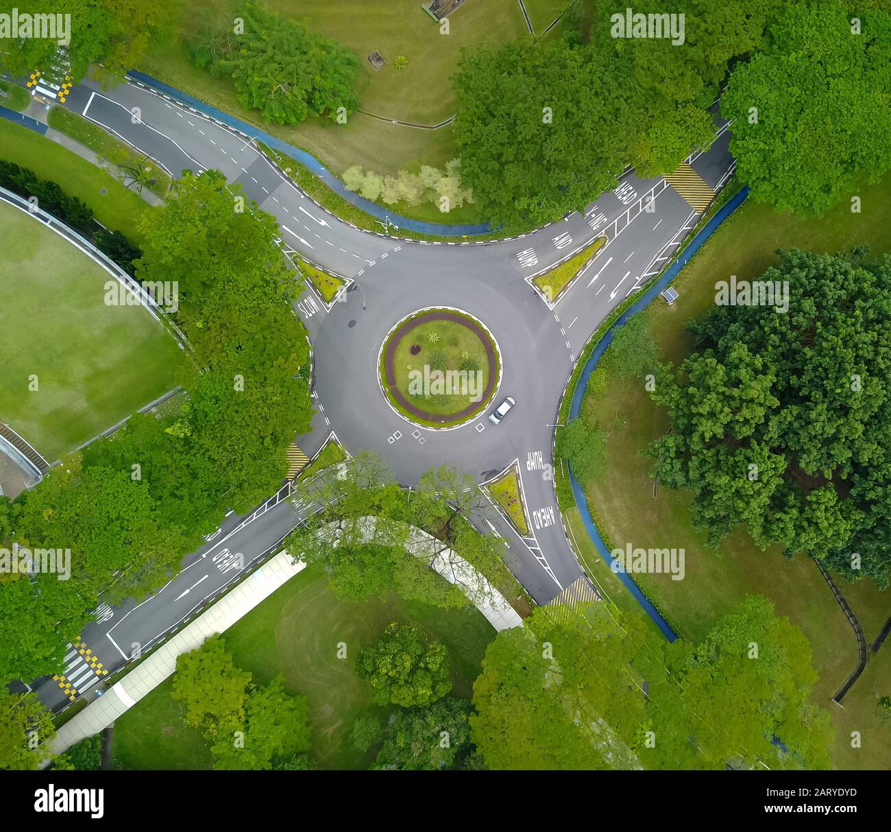 Aerial view of a junction with a car and road marks in a roundabout ...