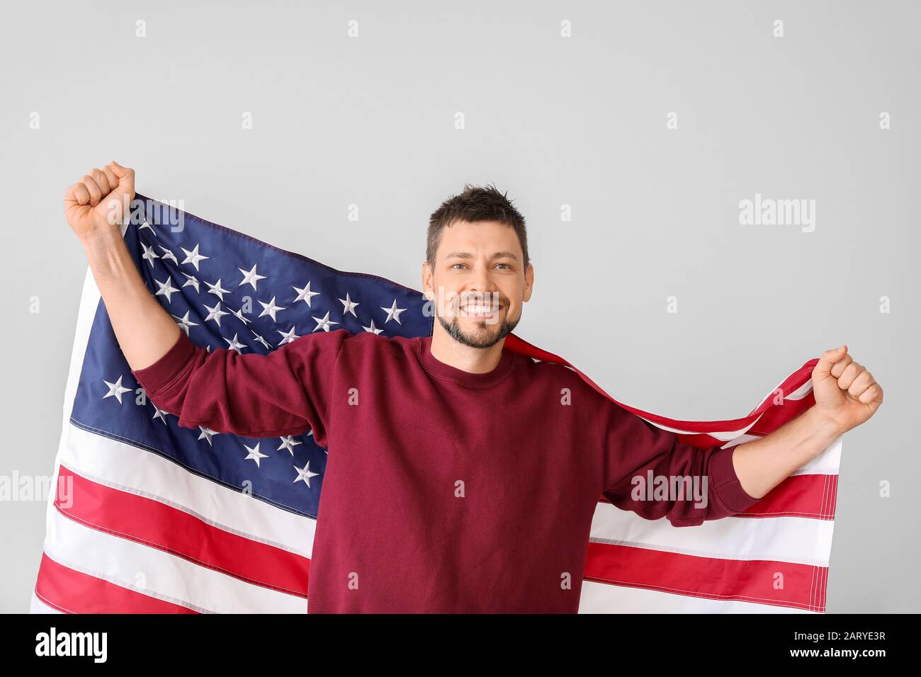 Handsome man with USA flag on light background. Memorial Day ...