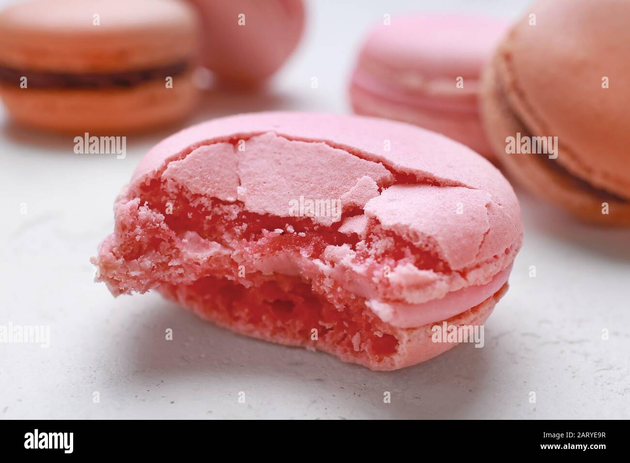 Bitten tasty macaron on white background Stock Photo - Alamy