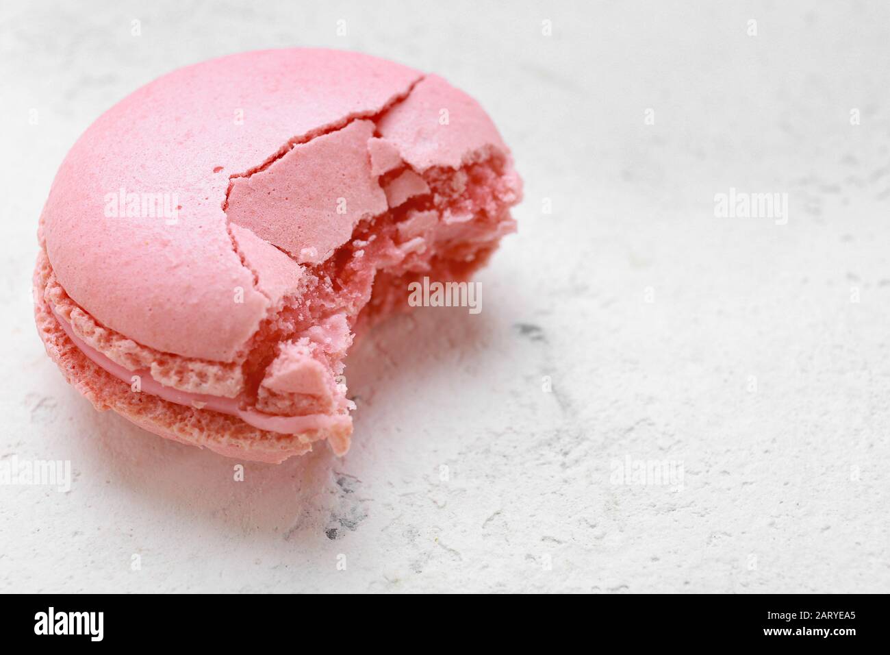 Bitten tasty macaron on white background Stock Photo - Alamy