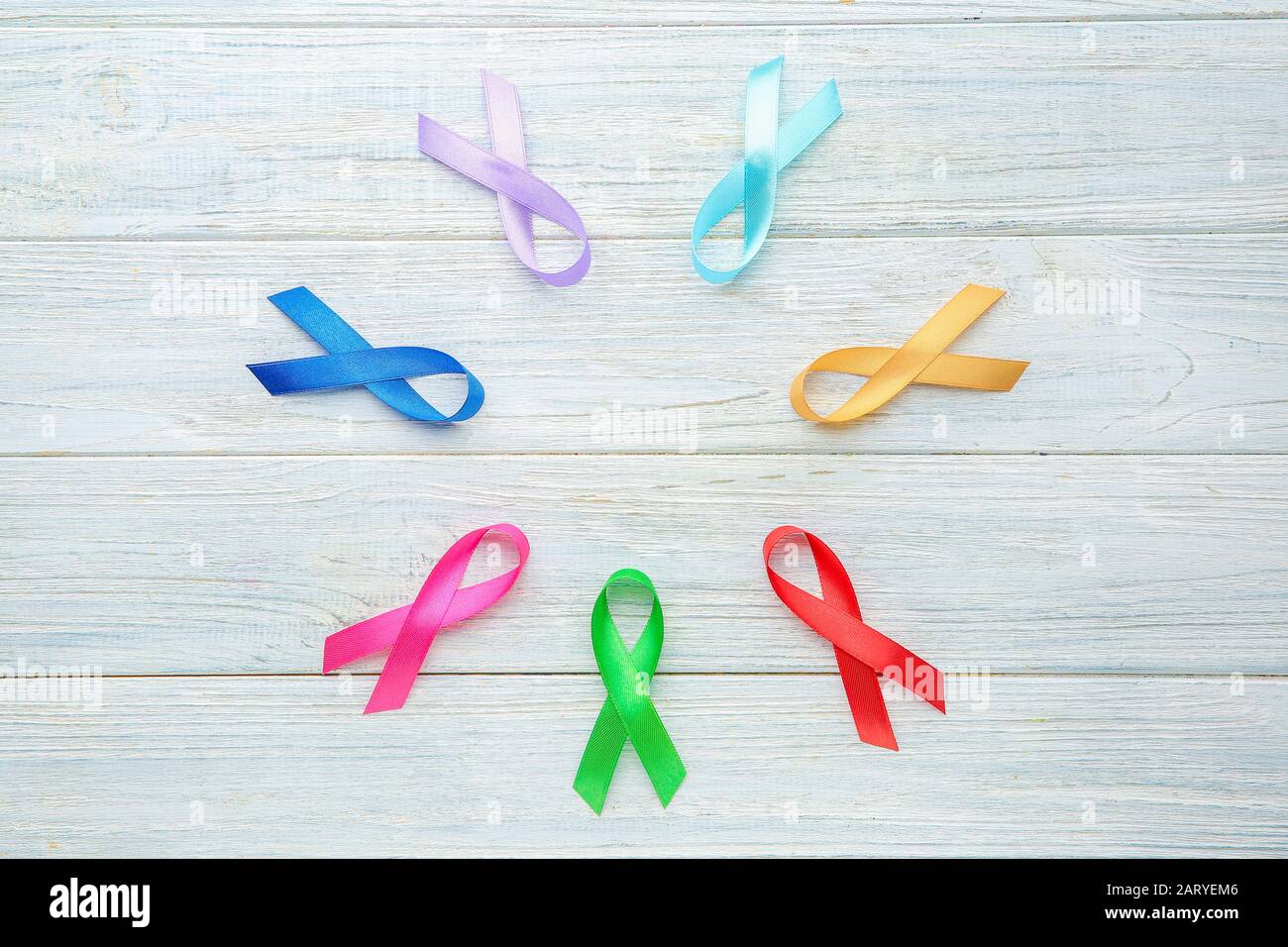 Different awareness ribbons on light wooden background Stock Photo - Alamy