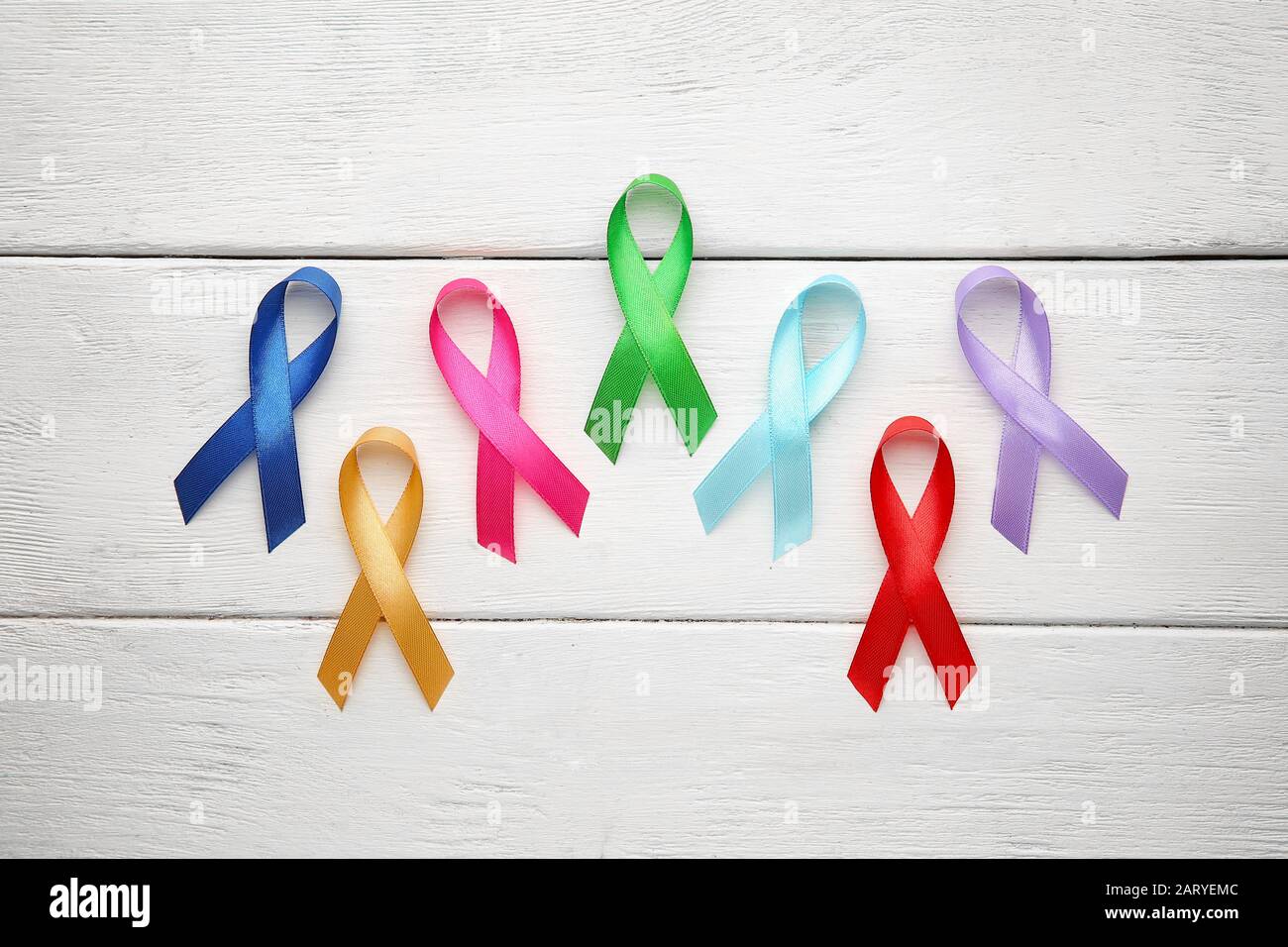 Different awareness ribbons on white wooden background Stock Photo - Alamy