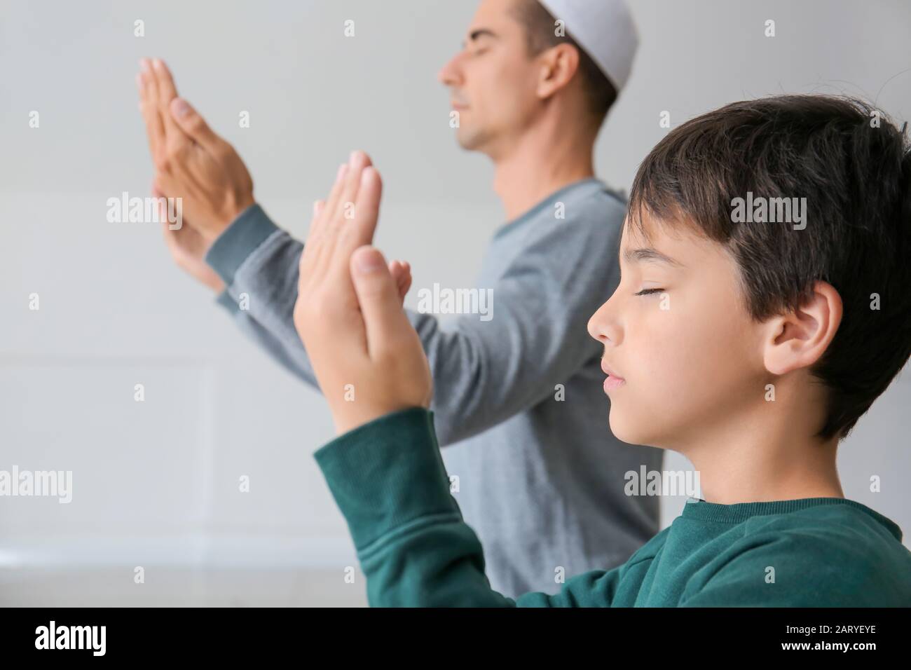 Muslim boy with father praying indoors Stock Photo - Alamy