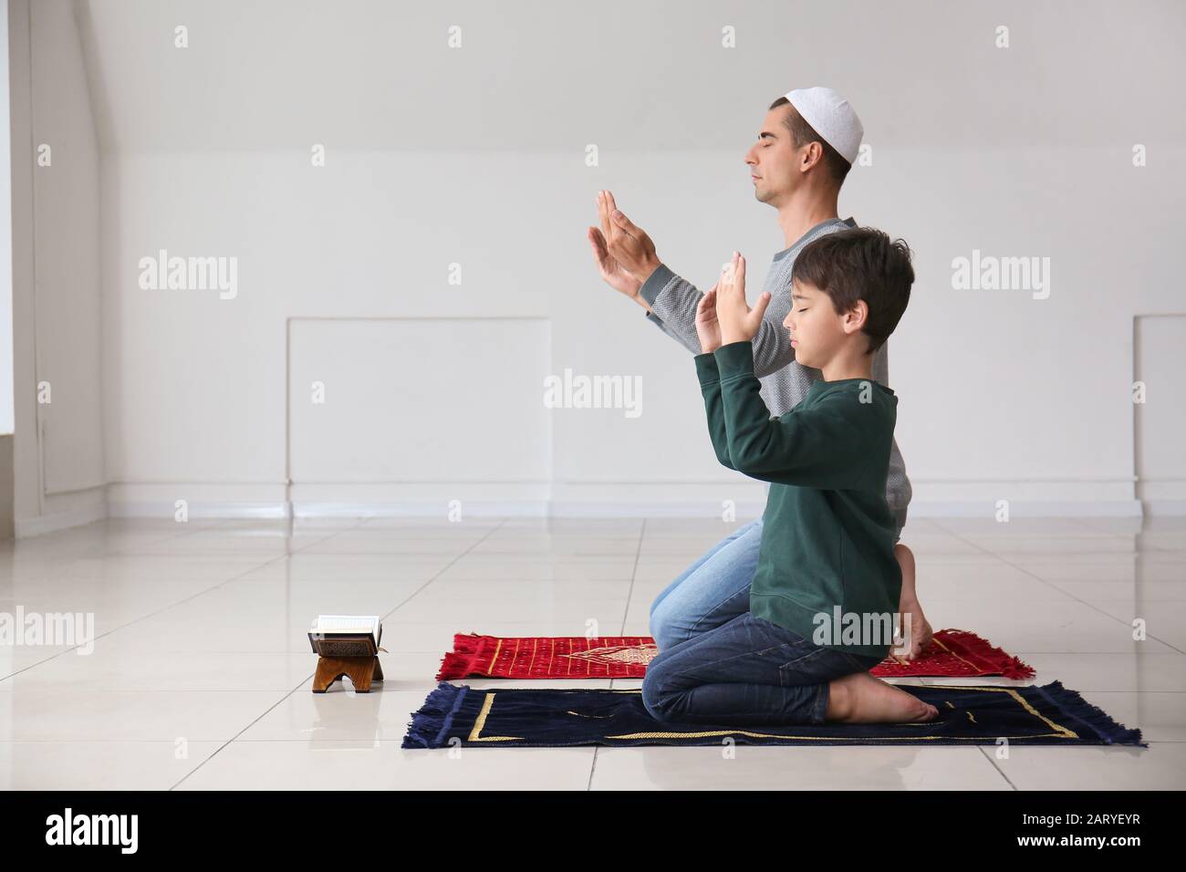 Muslim boy with father praying indoors Stock Photo - Alamy